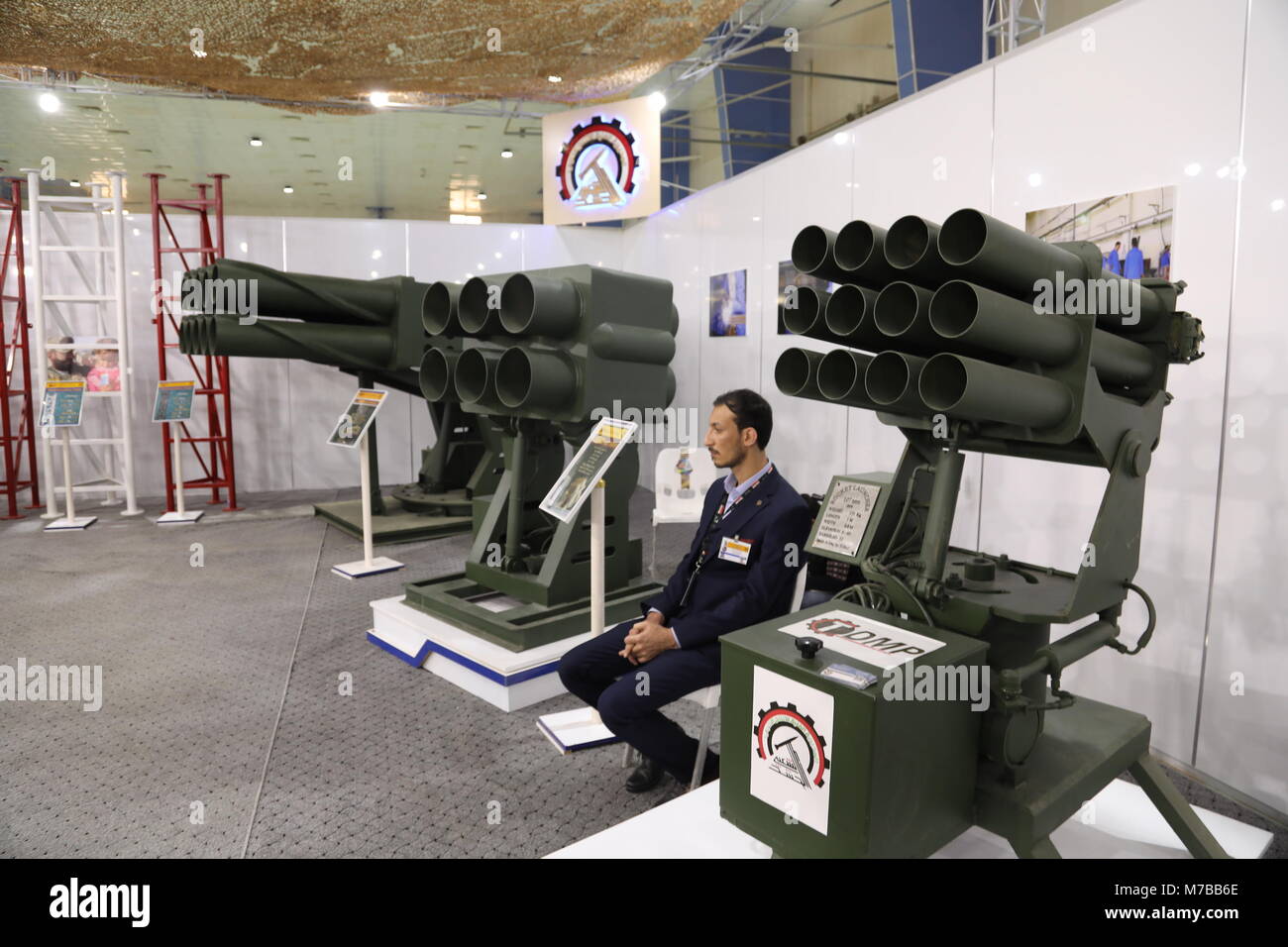Baghdad, Iraq. 10th Mar, 2018. An exhibitor sits between two rocket ...
