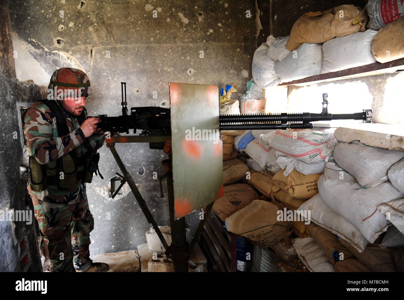 Damascus, Syria. 10th Mar, 2018. A Syrian soldier aims his machine gun ...
