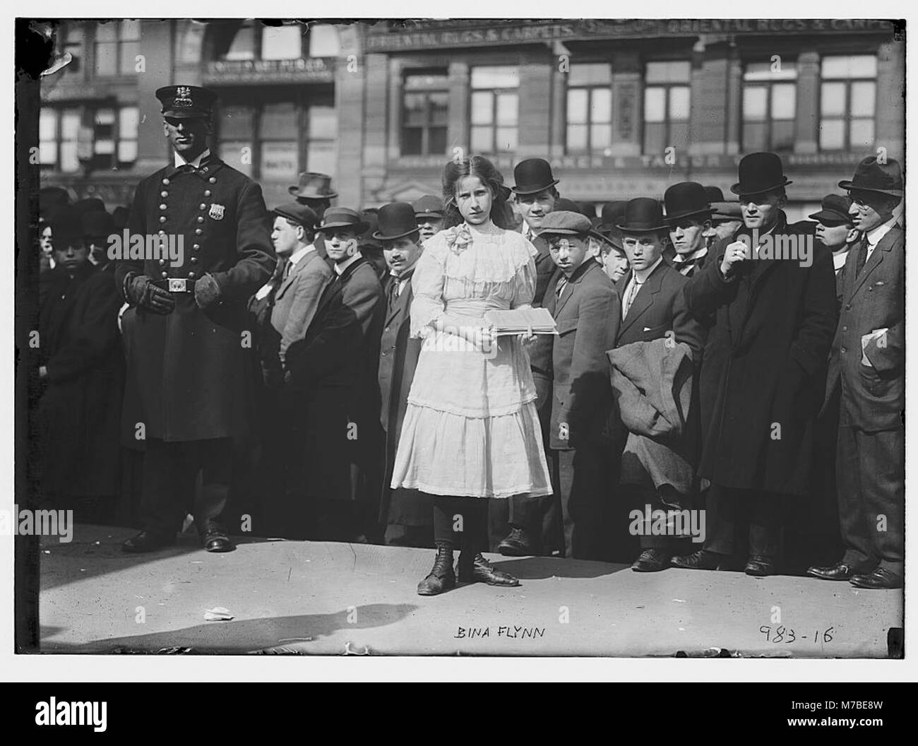 A historical image depicting Bina Flynn, a policeman, along with other ...