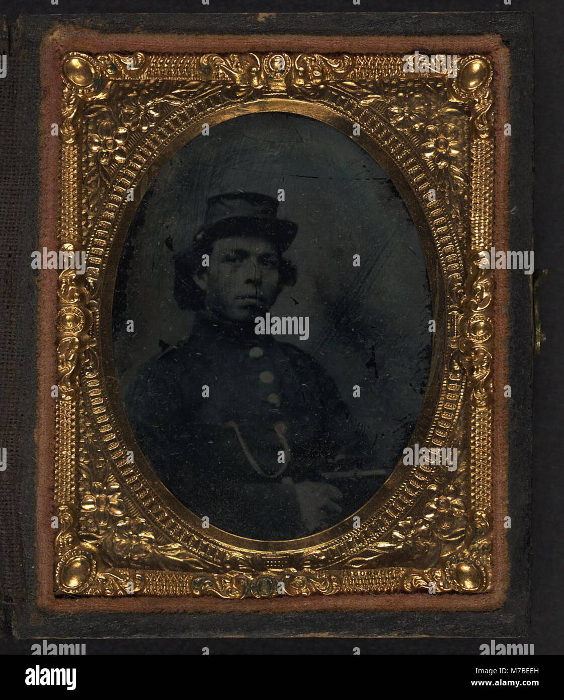 Black soldier seated with pistol in hand, watch chain in pocket ...
