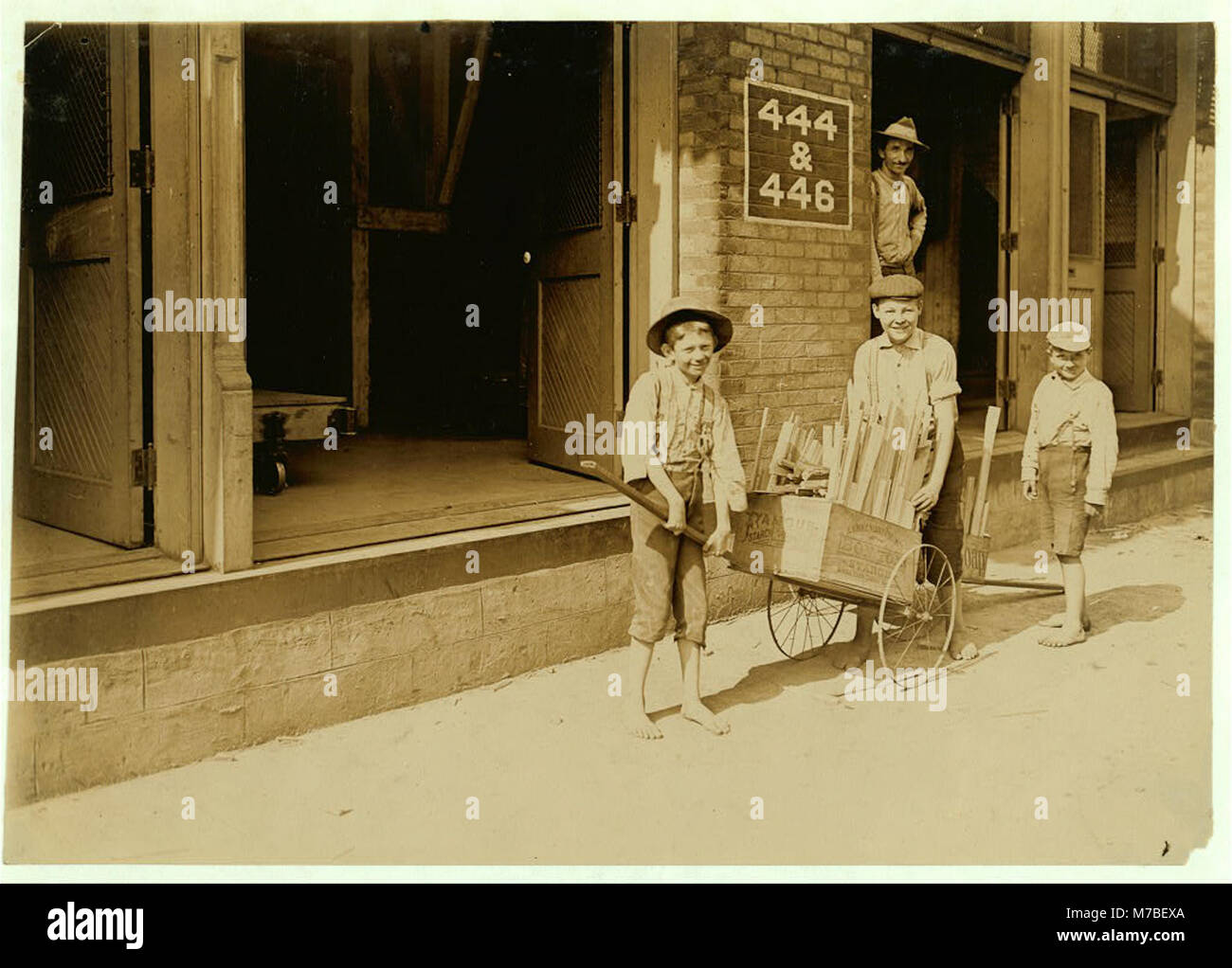 This 1908 photograph shows boys carrying firewood home from a factory ...
