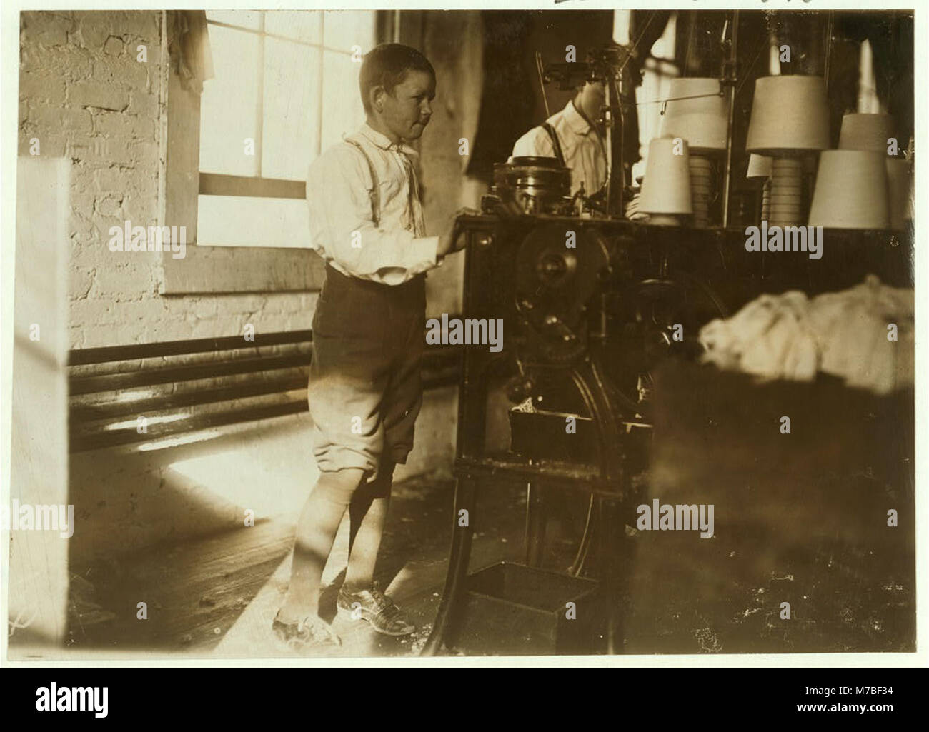 A photograph depicting a young boy working in the Talladega Hosiery ...