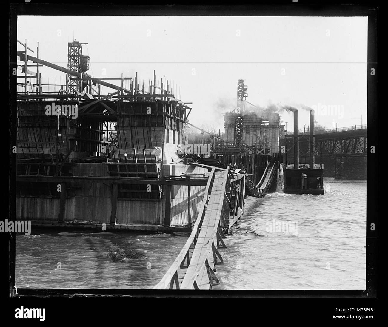 A photograph documenting the construction of a bridge, capturing ...