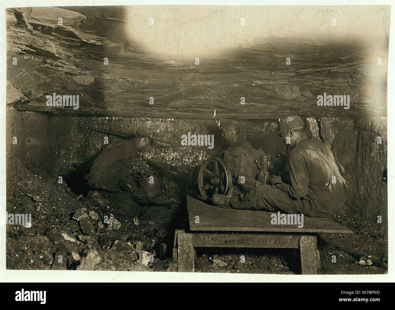 A miner working in Brown Mine, digging coal beneath a low ceiling ...