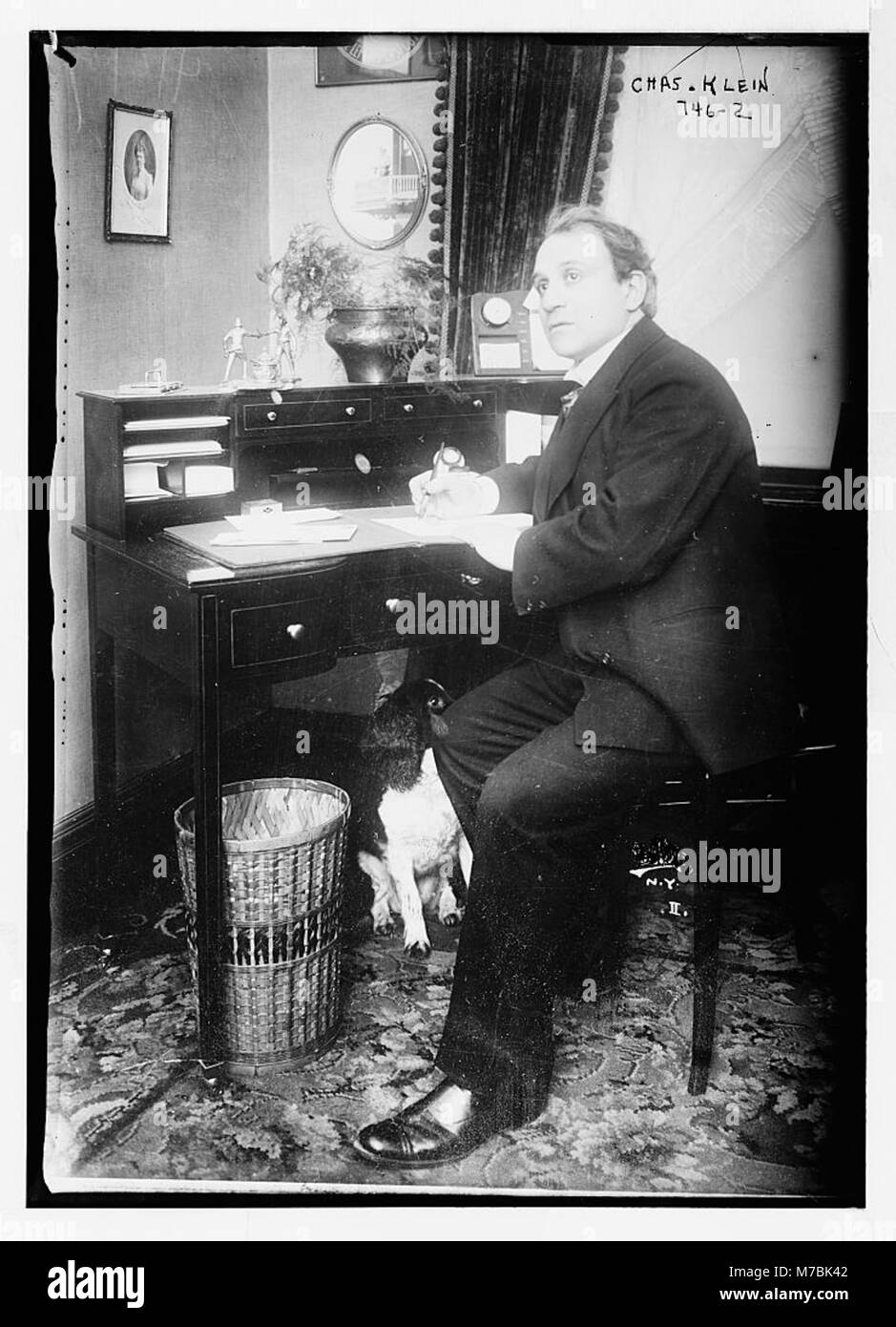 A historical image showing Charles Klein, a writer, at his desk ...