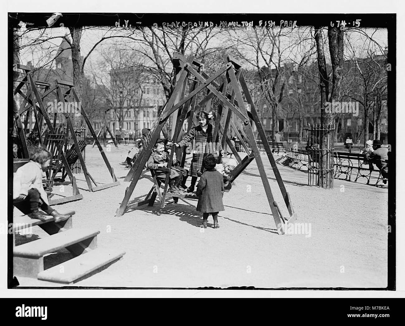 The image shows children playing on swings in Hamilton Fish Park ...