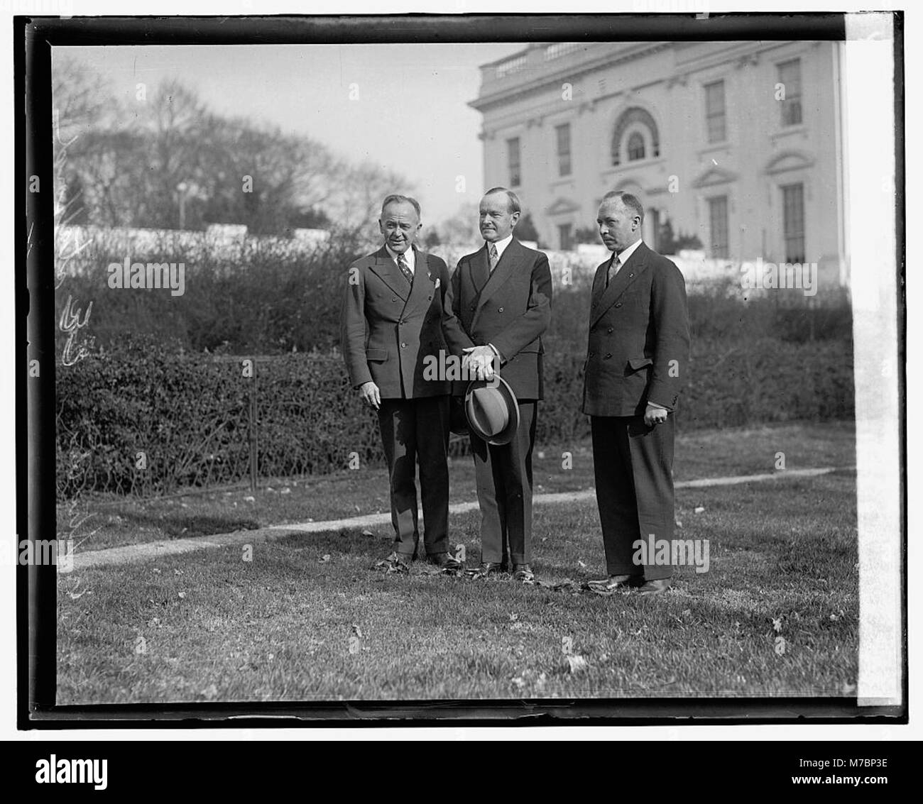 This photograph shows President Calvin Coolidge with two men standing ...