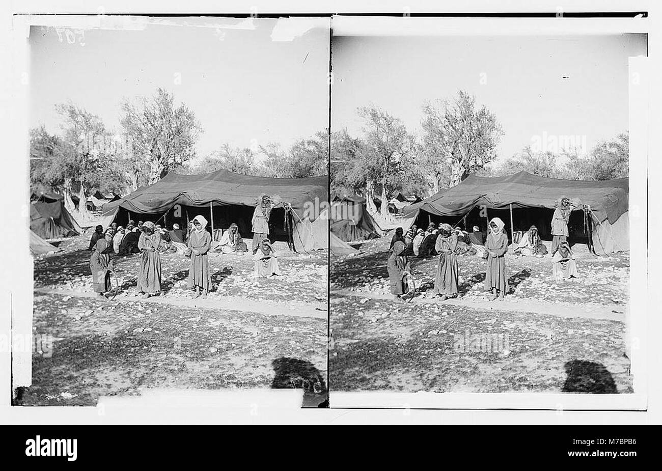 A photograph capturing a gypsy encampment, with individuals dressed in ...