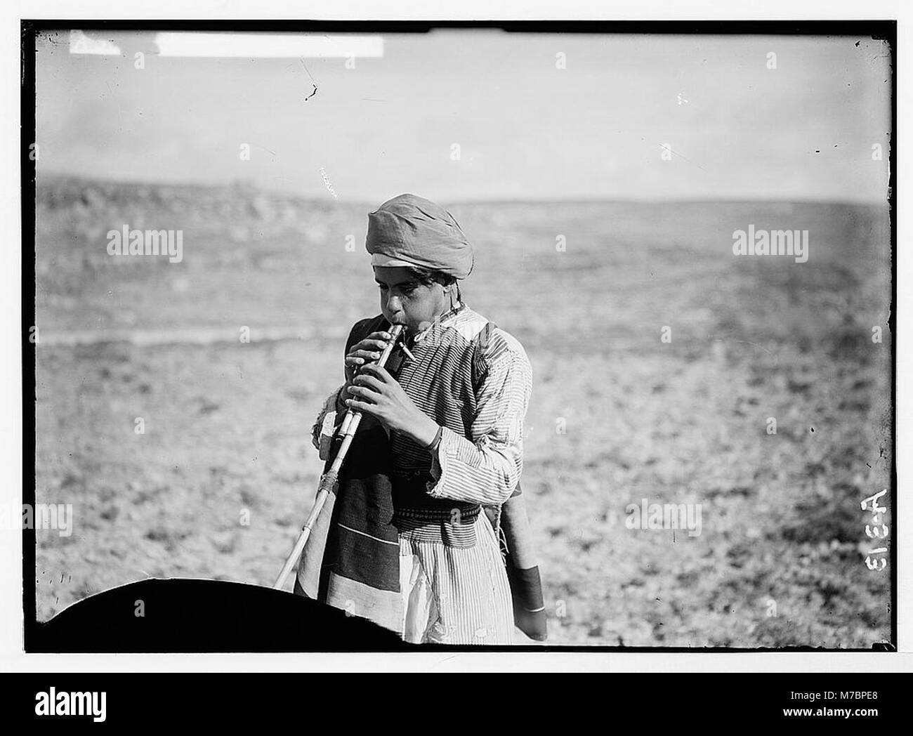 A photograph of a shepherd boy playing his flute, dressed in ...