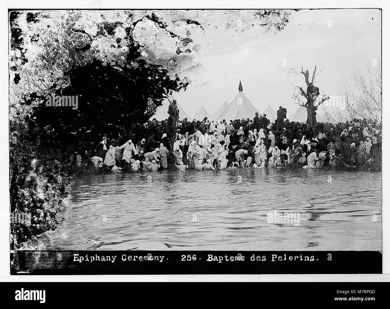 A scene depicting pilgrims immersing themselves in the Jordan River ...