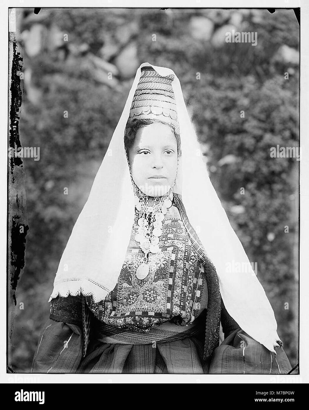 The photograph depicts a woman from Bethlehem dressed in traditional ...