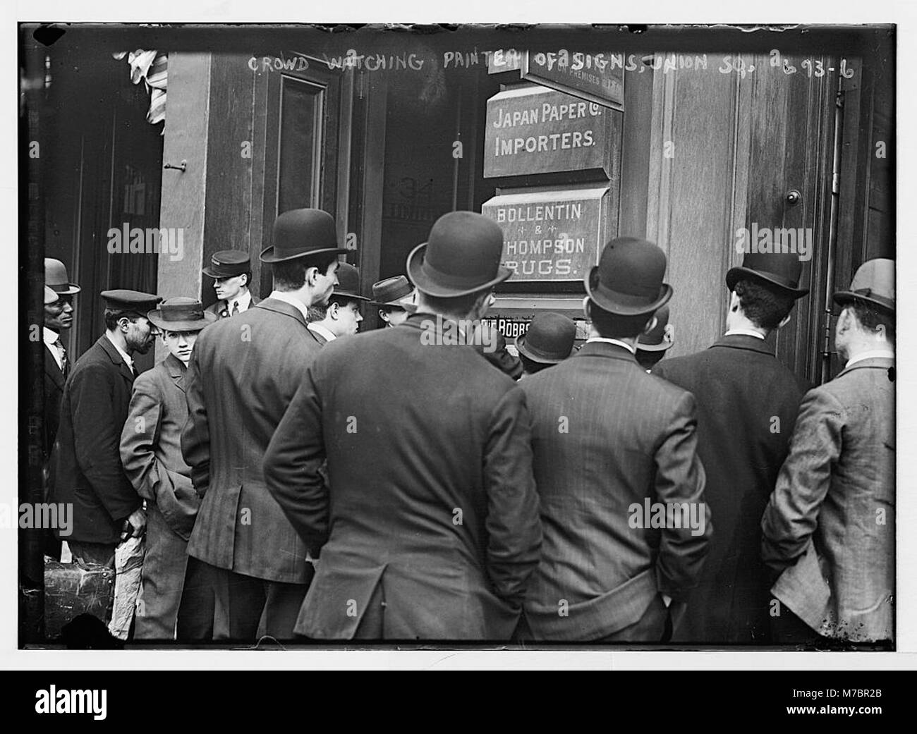 This image captures a crowd observing a sign painter at work in Union ...