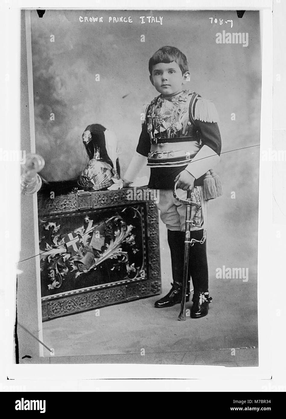 The Crown Prince of Italy is depicted in uniform, holding a sword ...