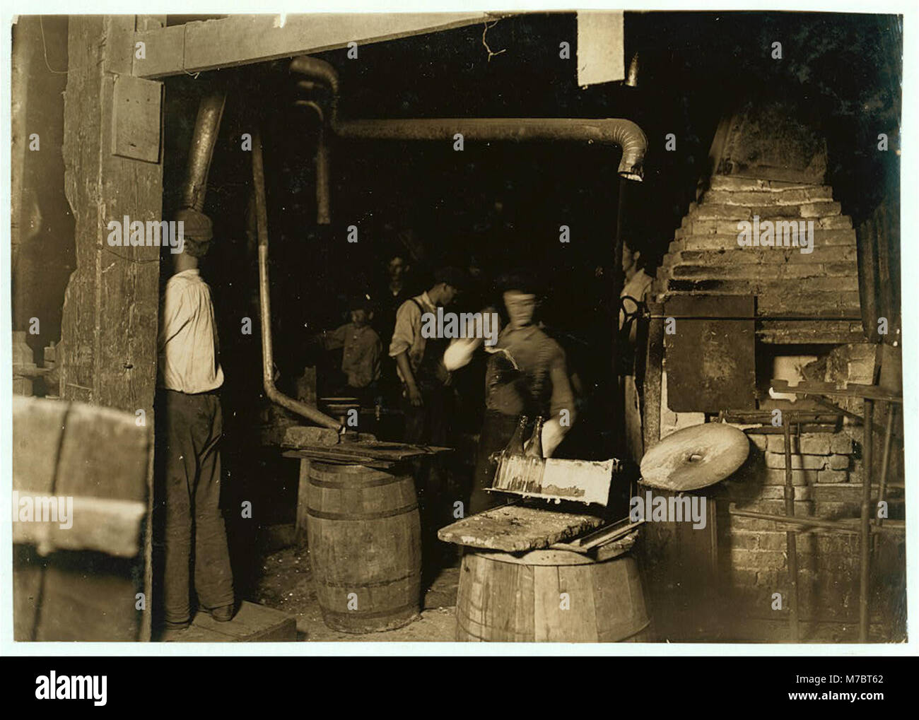 A daytime photograph of workers at an Indiana Glass Works factory in ...
