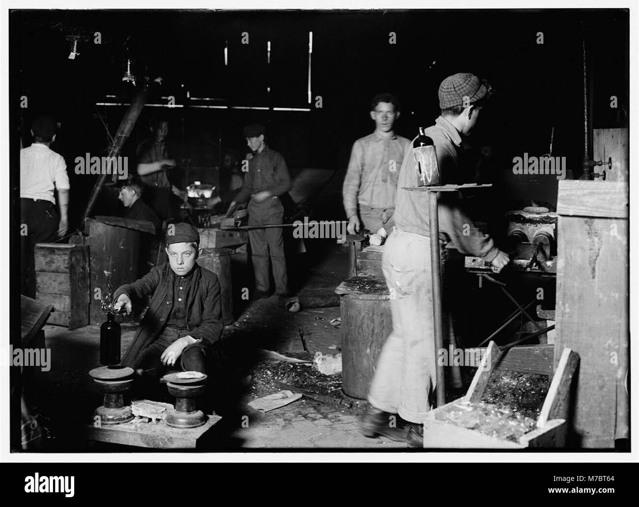 This photograph depicts a day scene inside a New Jersey glass factory ...