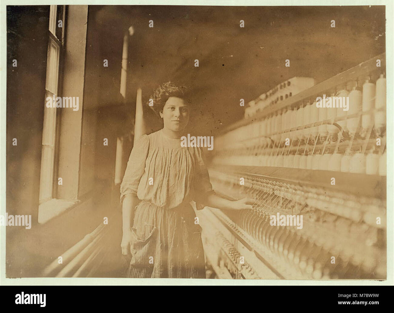 A photograph of a young girl working as a spinner and doffer at ...