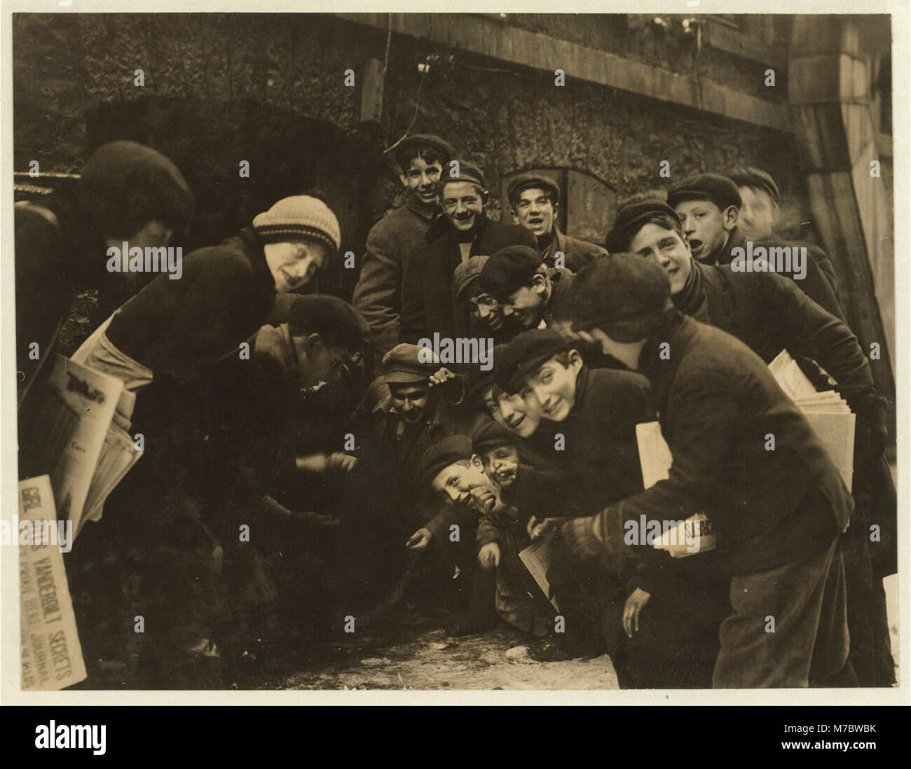 A group of individuals participate in a street dice game, referred to ...