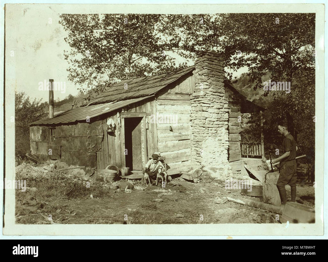 This photograph depicts a small log cabin, once part of early American ...