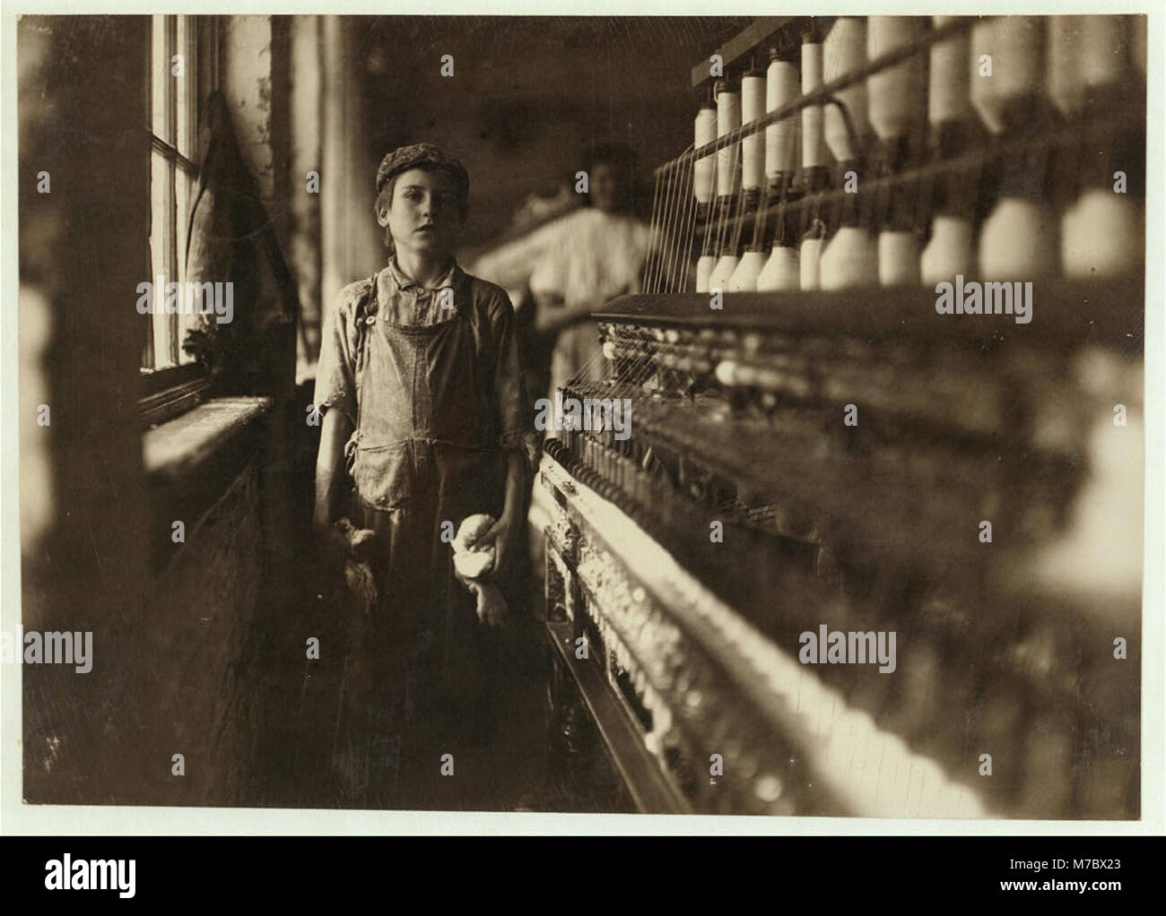 A young worker is shown at Central Mills, performing the task of ...
