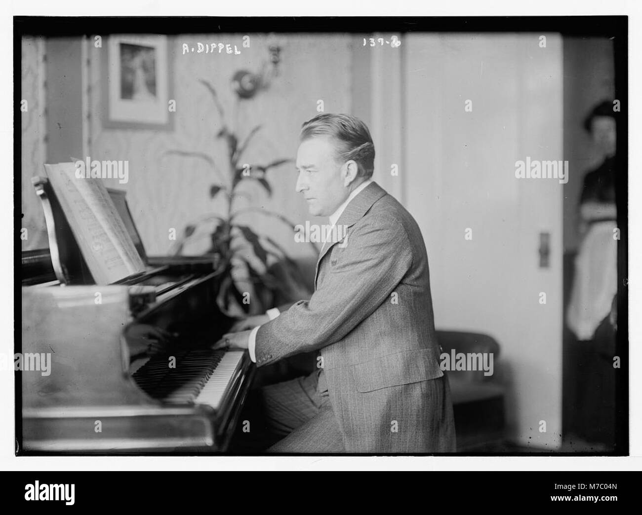 This photograph of Andreas Dippel features him playing a piano ...