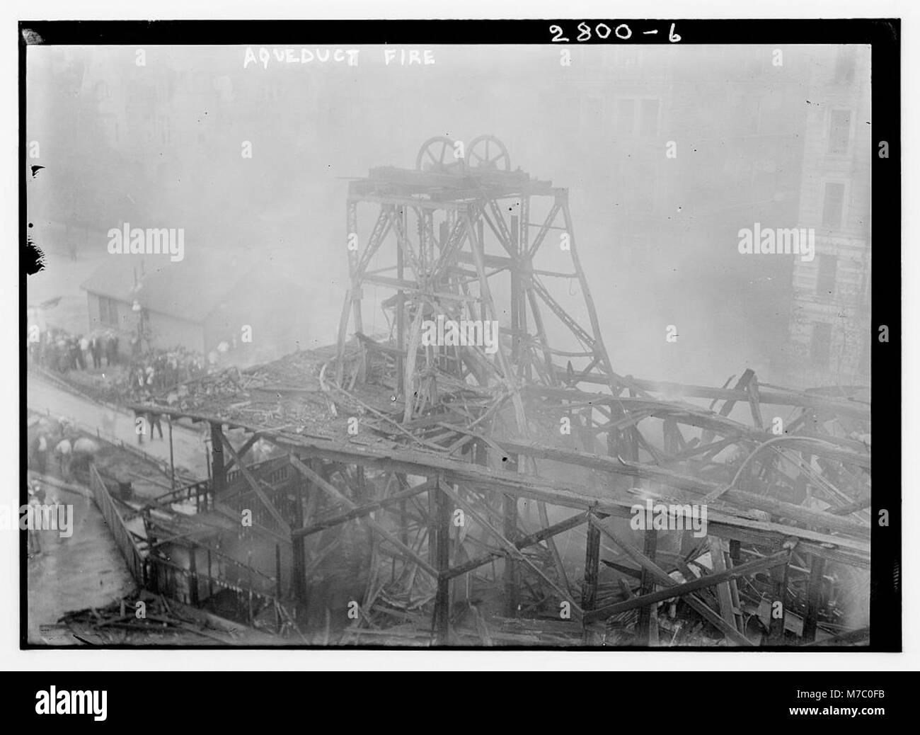 A photograph documenting the aftermath of a fire at an aqueduct. The ...