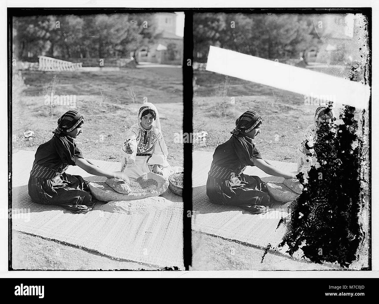 Arab women are seen working at a primitive grain mill, depicting ...