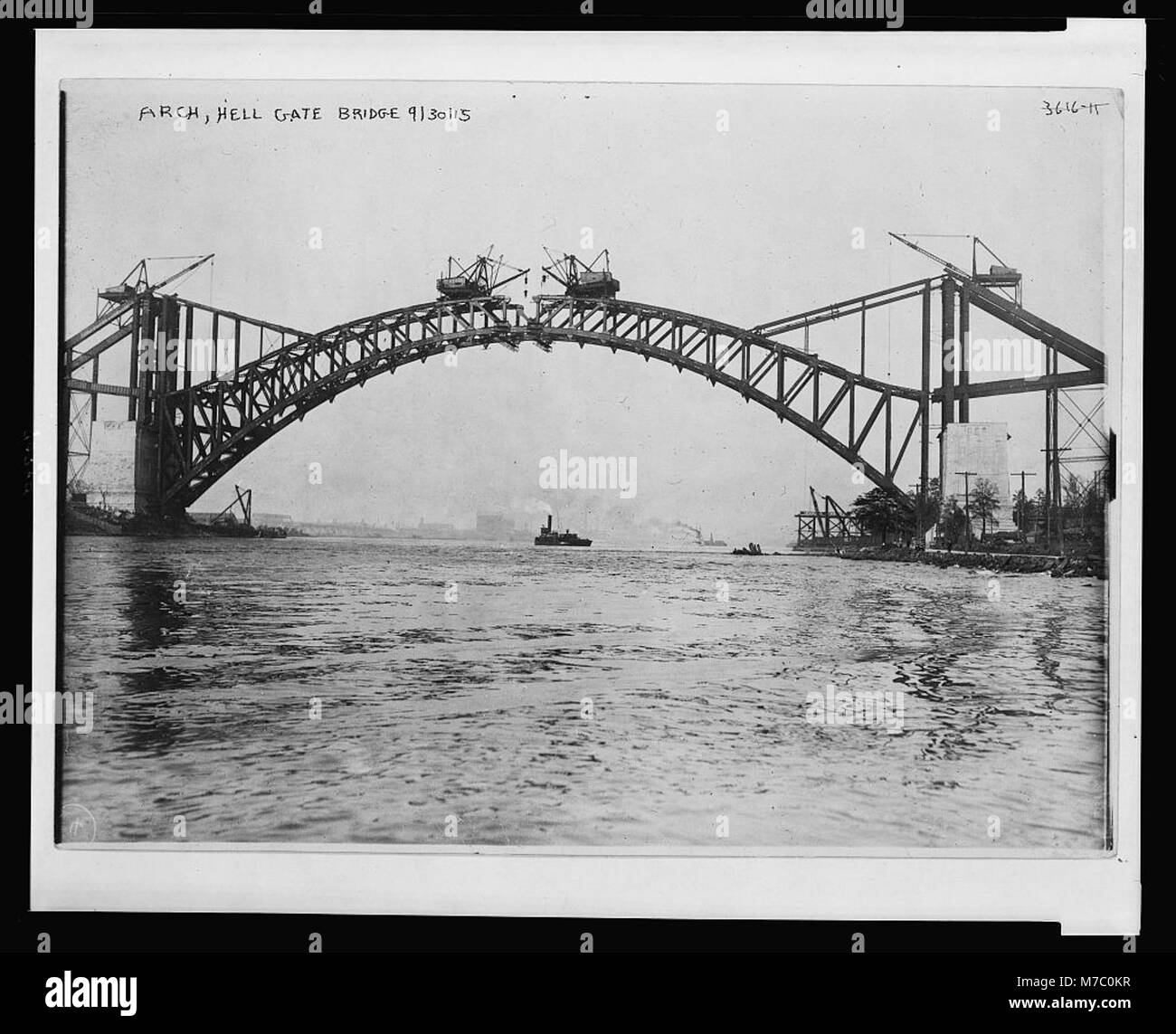 A photo capturing the under-construction arch of the Hell Gate Bridge in New York City. The ...