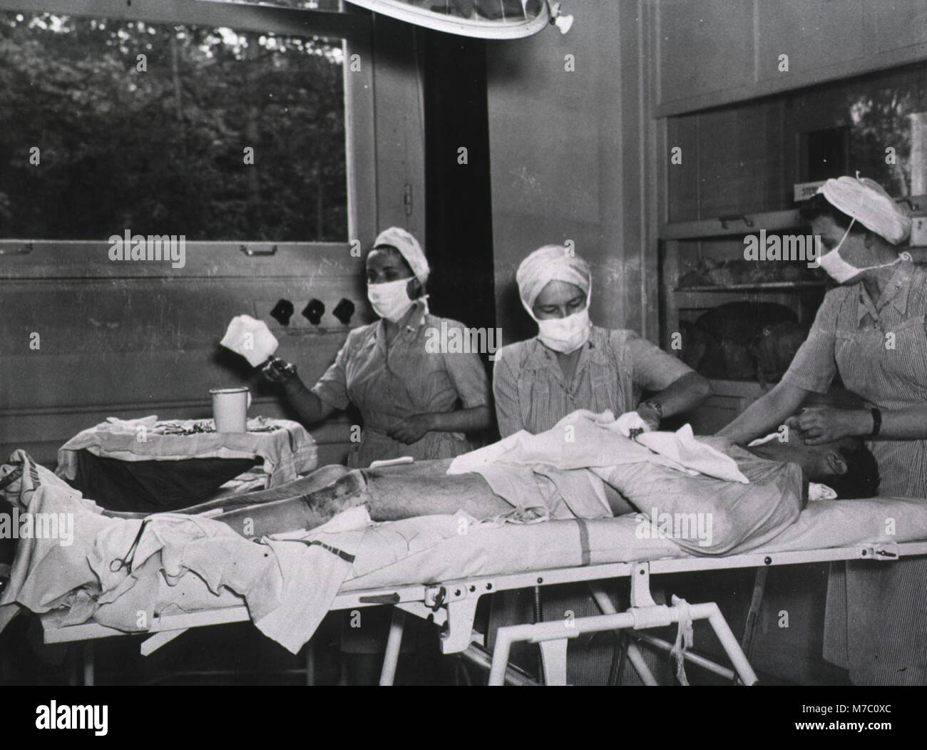 A historical photograph showing Army nurses in the operating room at ...
