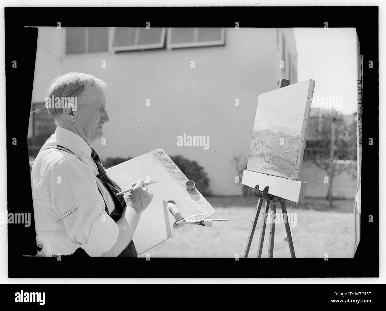 Eric Matson, an artist, is depicted painting at an easel, likely in ...