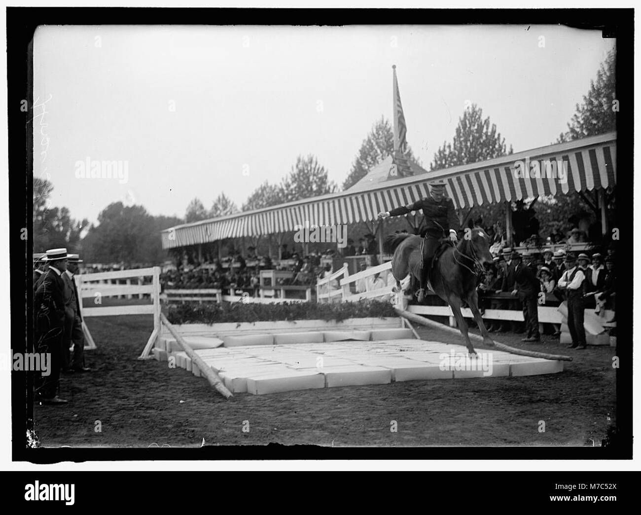 A photograph from a horse show featuring a broad jump event, capturing ...