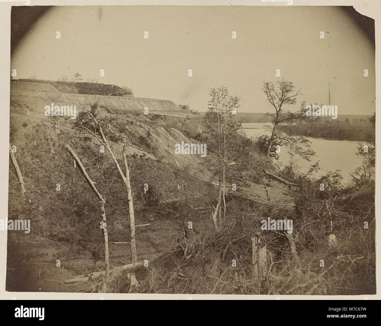 A photograph of a sloped hill near a river, capturing the natural ...