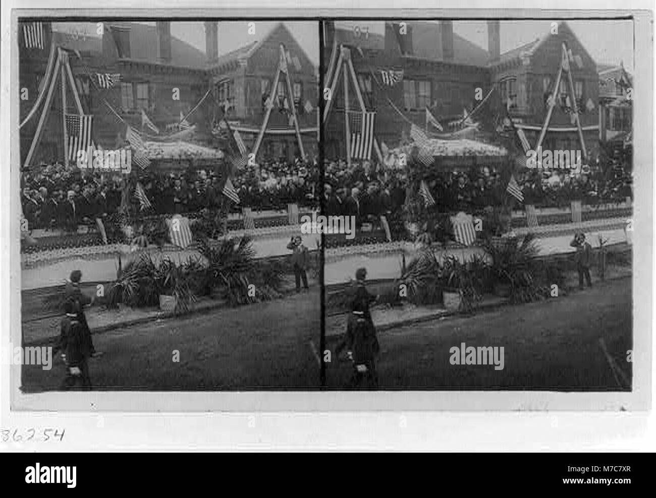 Theodore Roosevelt is shown with a crowd on a decorated rostrum ...