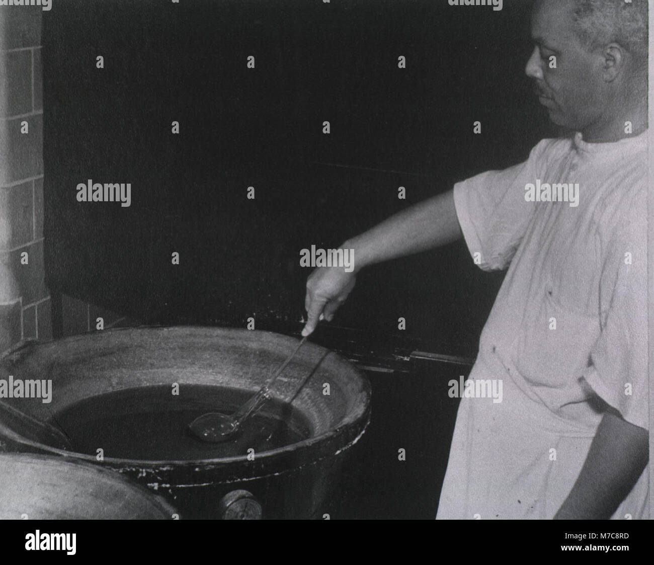 This image shows a laboratory technician disinfecting a glass beaker ...