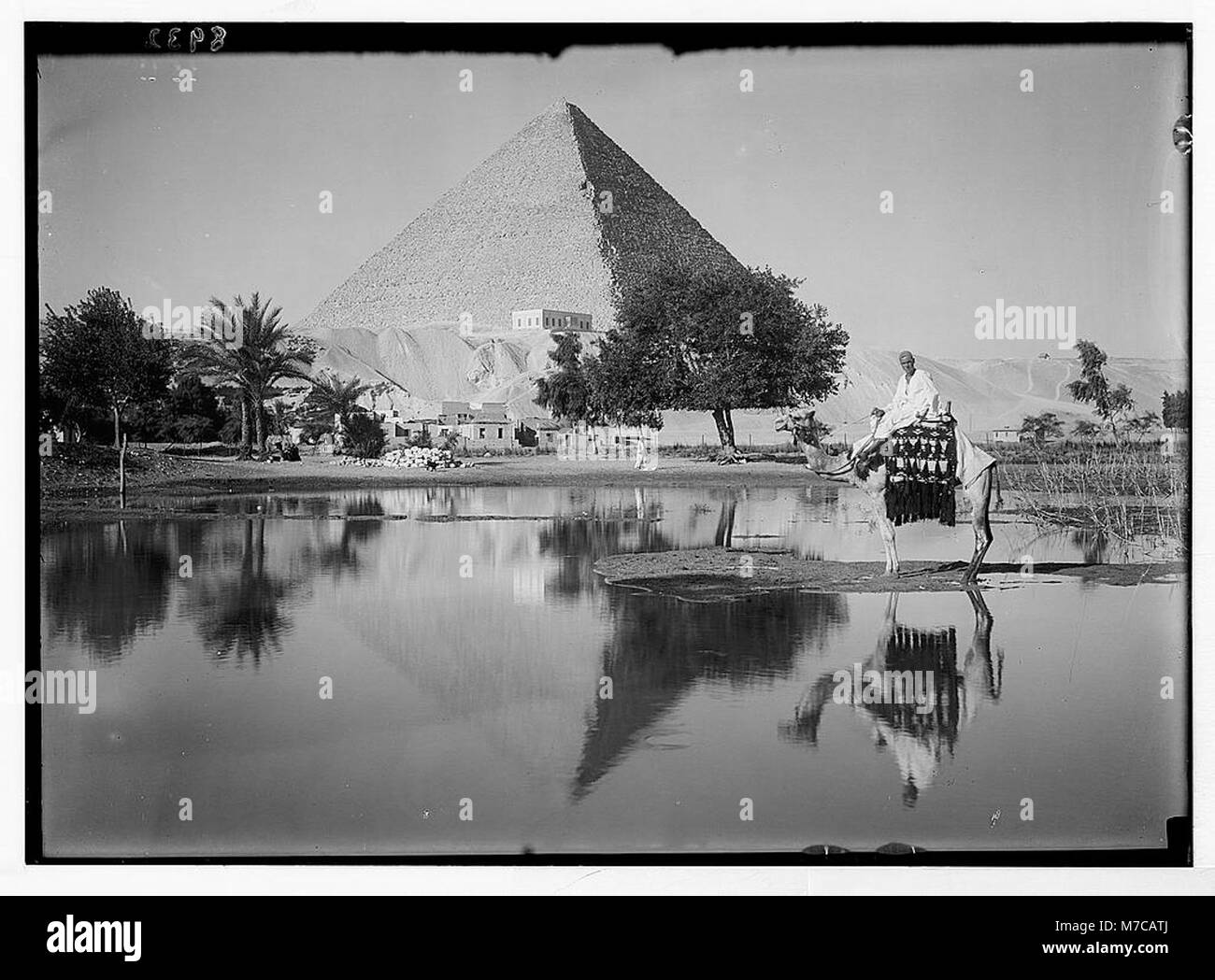 This photograph shows the Pyramids of Giza in Egypt, with a reflection ...