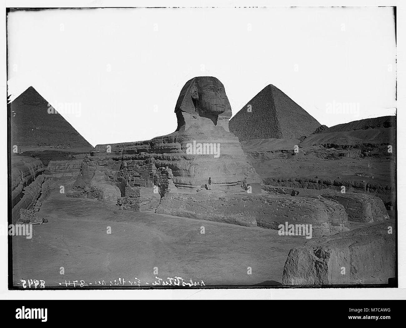 A classic view of the Egyptian Sphinx with two pyramids in the ...