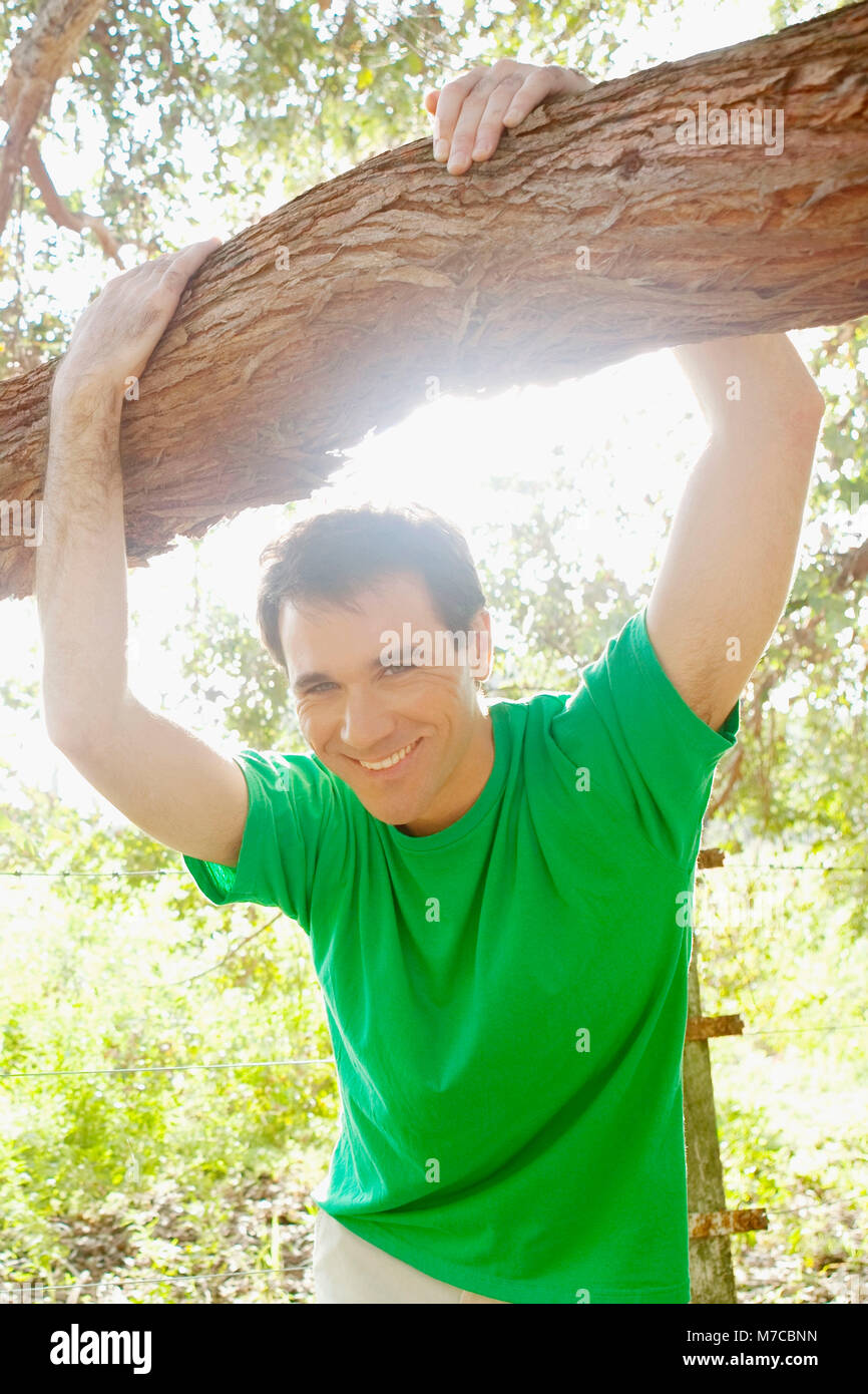 Man hanging on a tree branch Stock Photo - Alamy