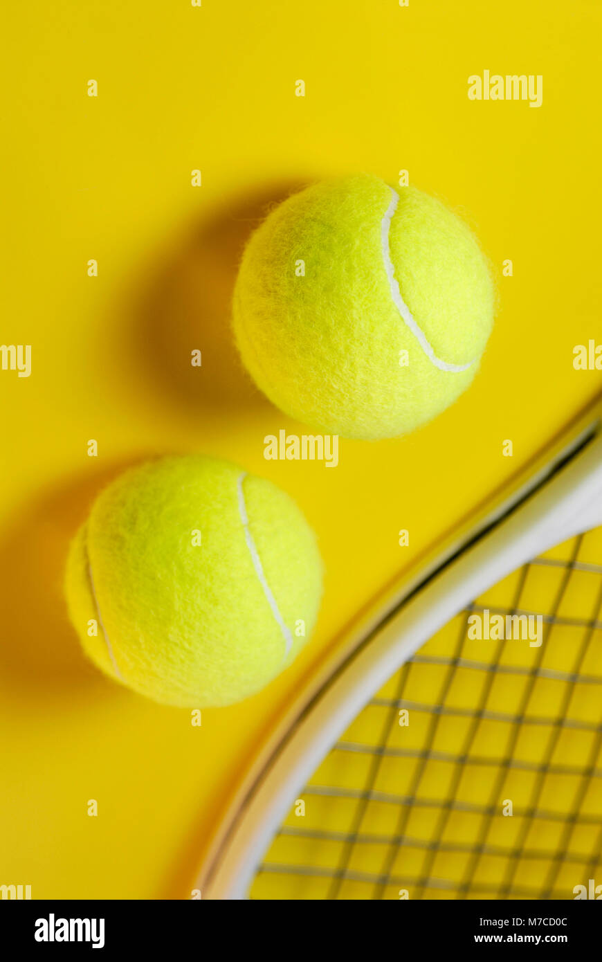 Close-up of two tennis balls with a tennis racket Stock Photo - Alamy