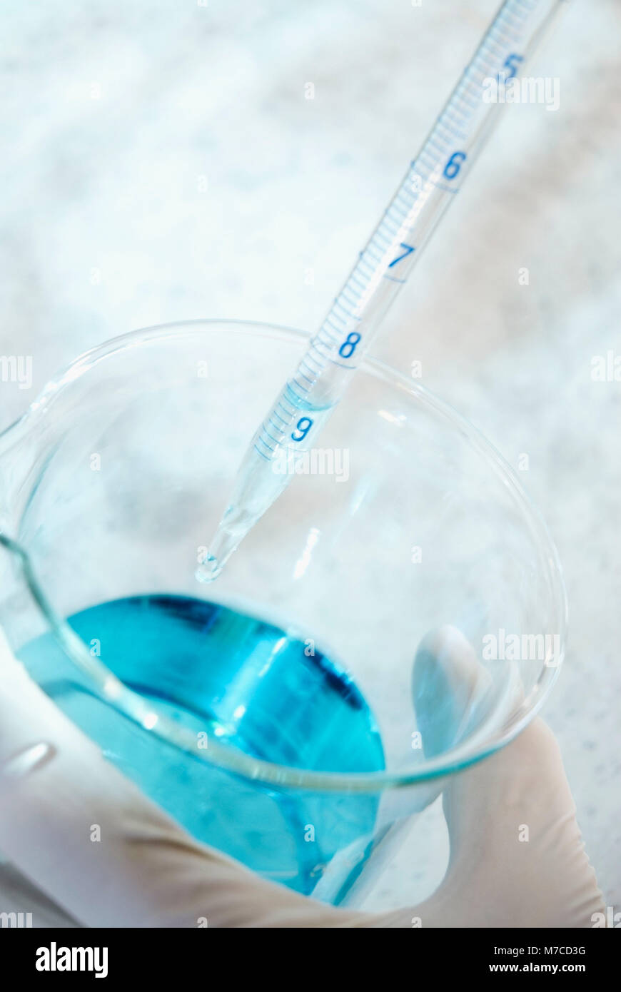 Liquid dropping into a beaker using a pipette hi-res stock photography ...