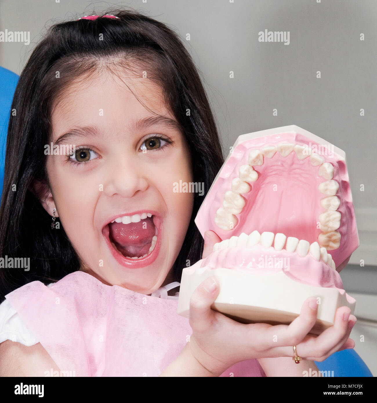 Portrait of a girl holding a set of dentures Stock Photo - Alamy