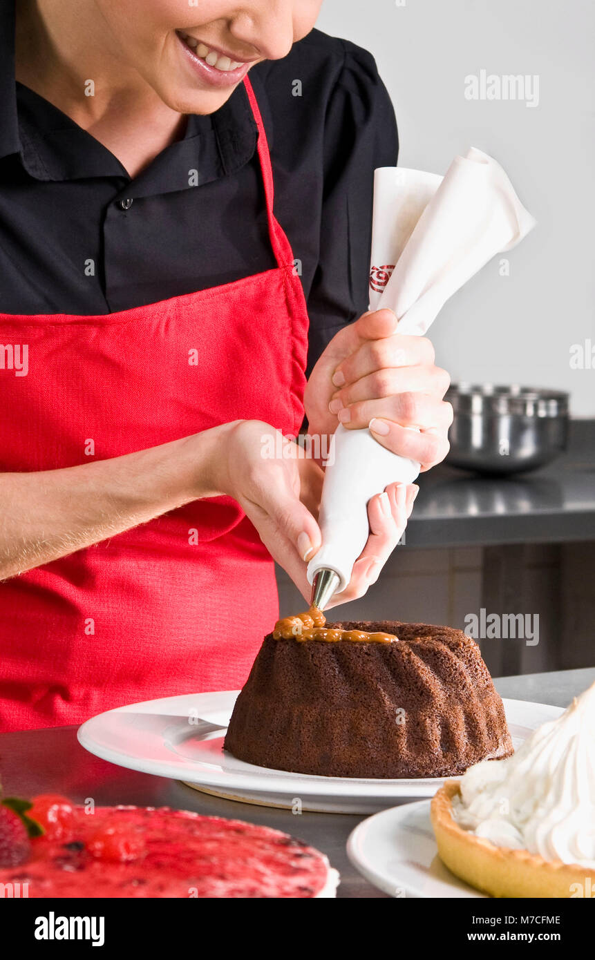 Female chef icing a cake Stock Photo - Alamy