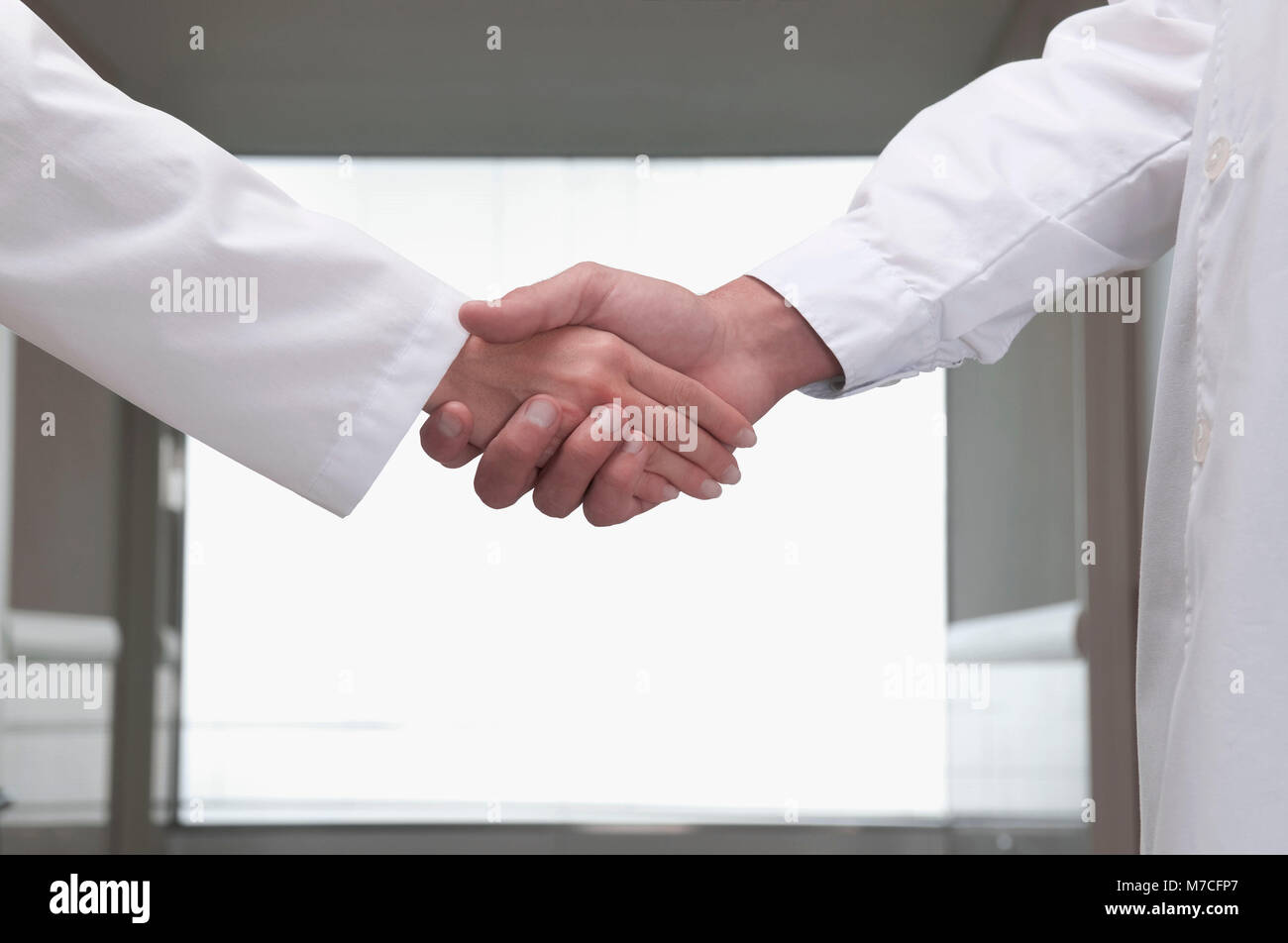 Two doctors shaking hands in a hospital Stock Photo - Alamy