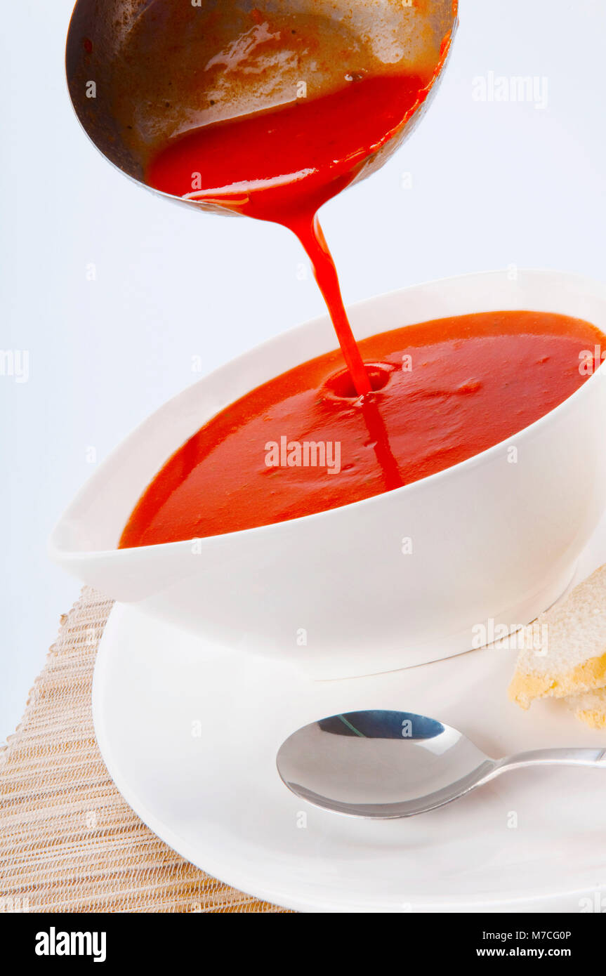 Close-up of tomato soup being poured into a bowl Stock Photo - Alamy