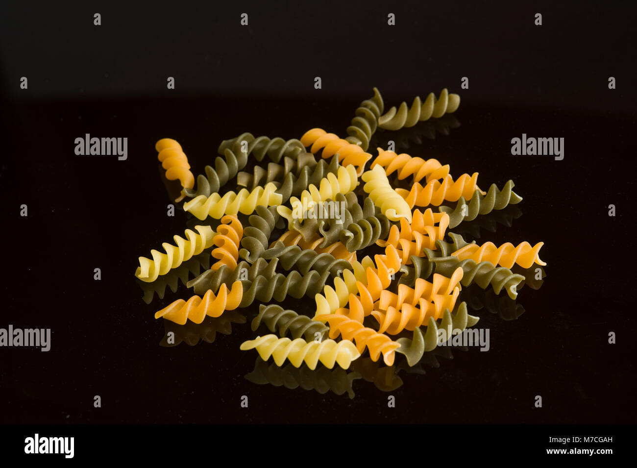 Close-up of raw spiral fusilli on a black background Stock Photo - Alamy