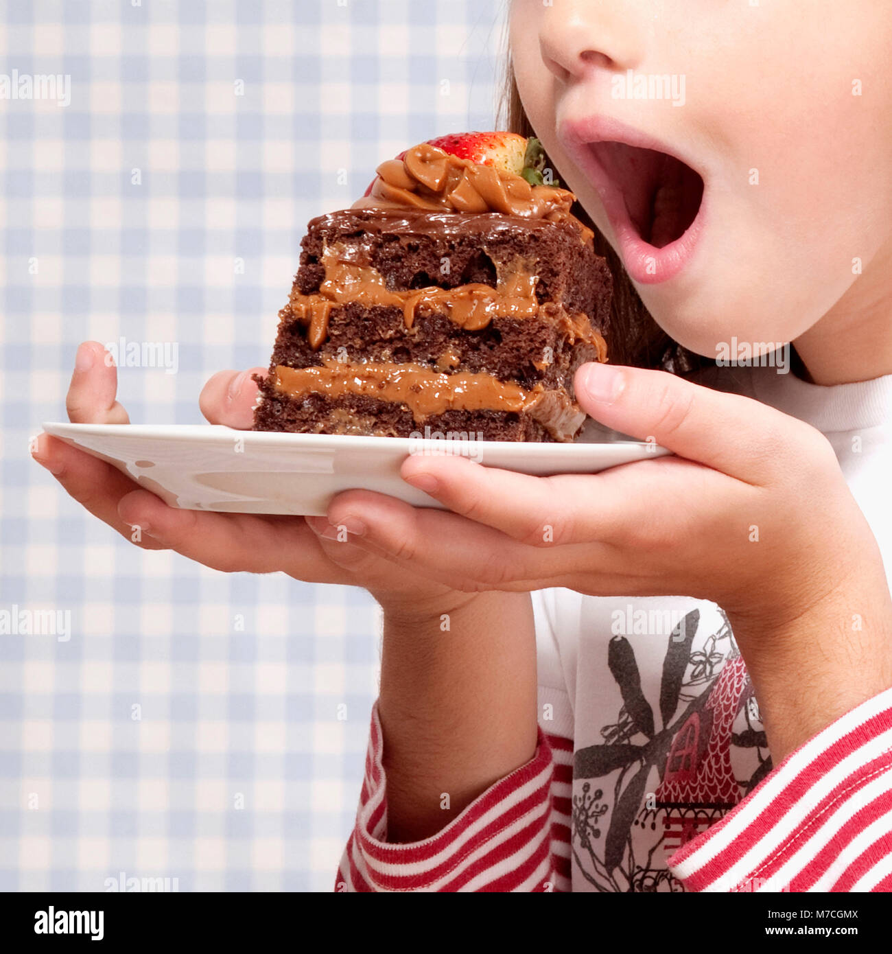 Girl eating a slice of chocolate pastry Stock Photo - Alamy