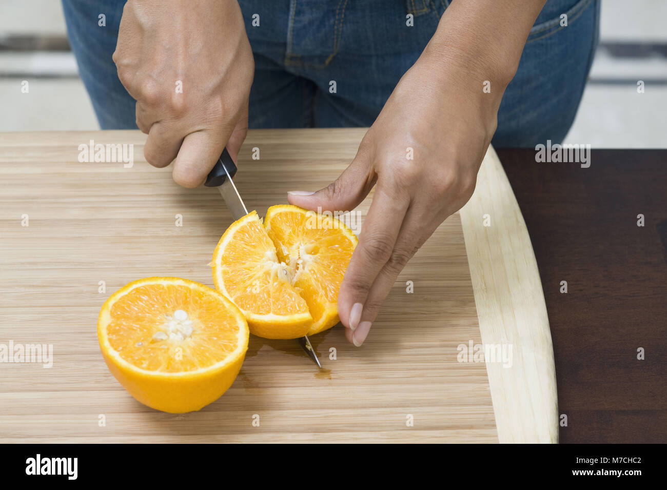 Mid section view of a woman cutting an orange Stock Photo - Alamy