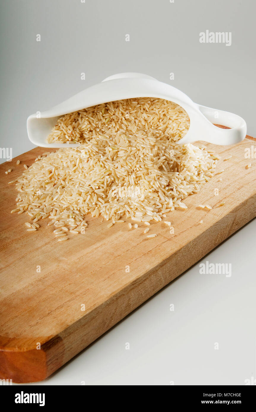 Close-up of brown rice spilling from a ceramic jug Stock Photo - Alamy