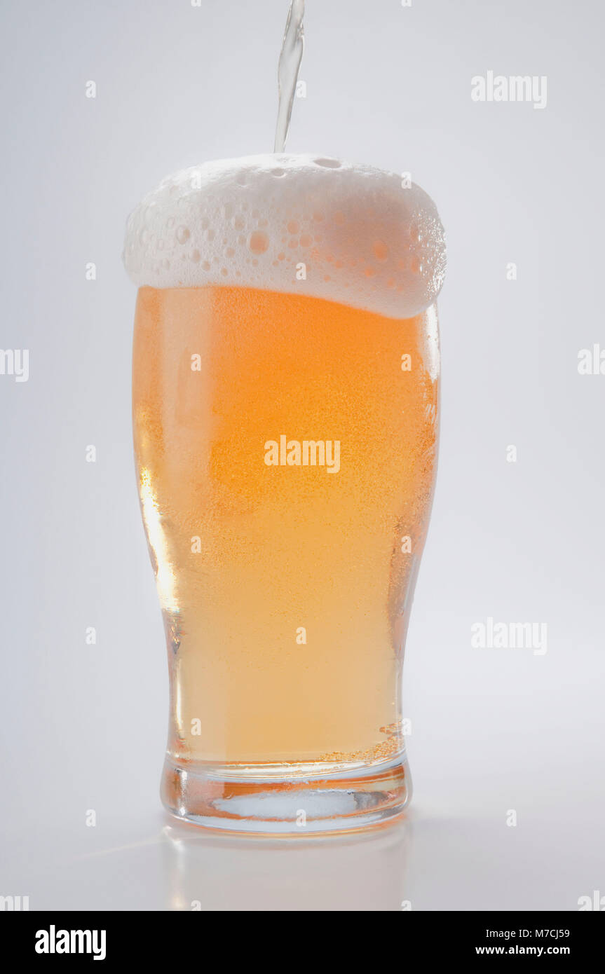 Close-up of an overflown beer glass Stock Photo - Alamy