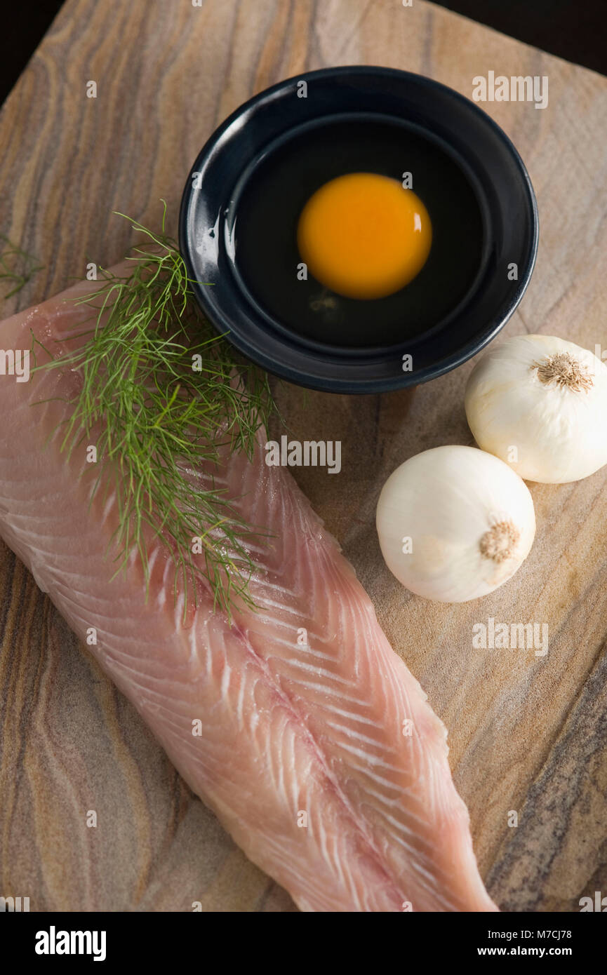 Slice of fish with egg yolk and onions Stock Photo - Alamy