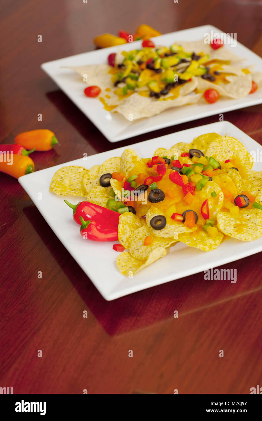 Chips topped with peppers and olives Stock Photo - Alamy