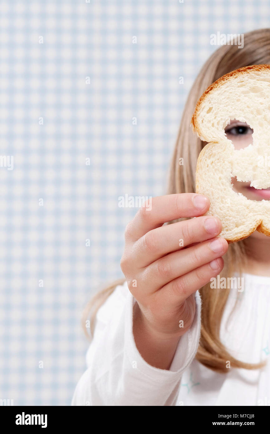Girl holding a slice of bread with smiley face hi-res stock photography ...